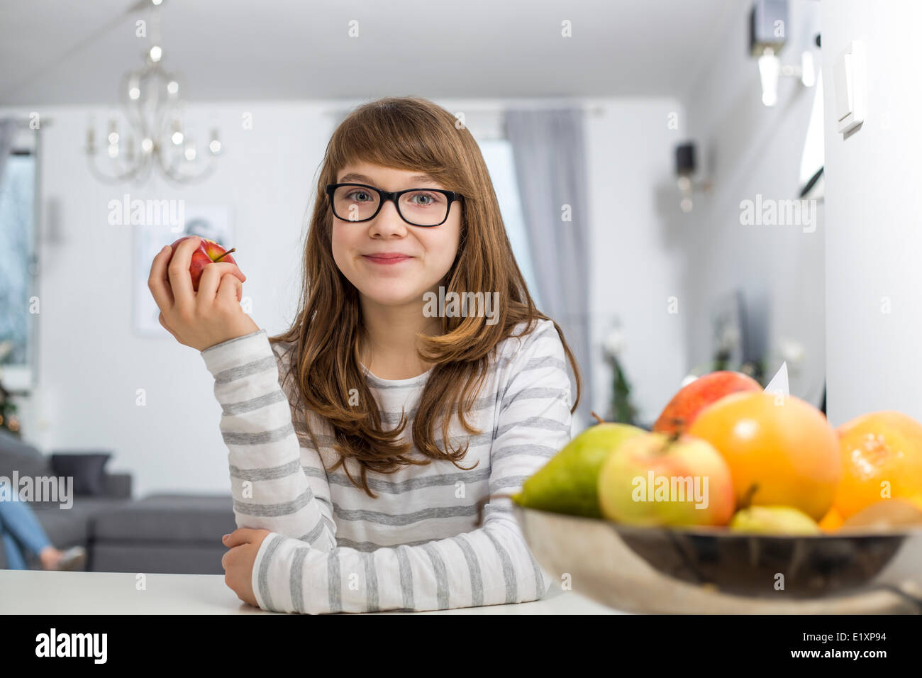 Portrait of teenage girl holding apple at home Stock Photo - Alamy