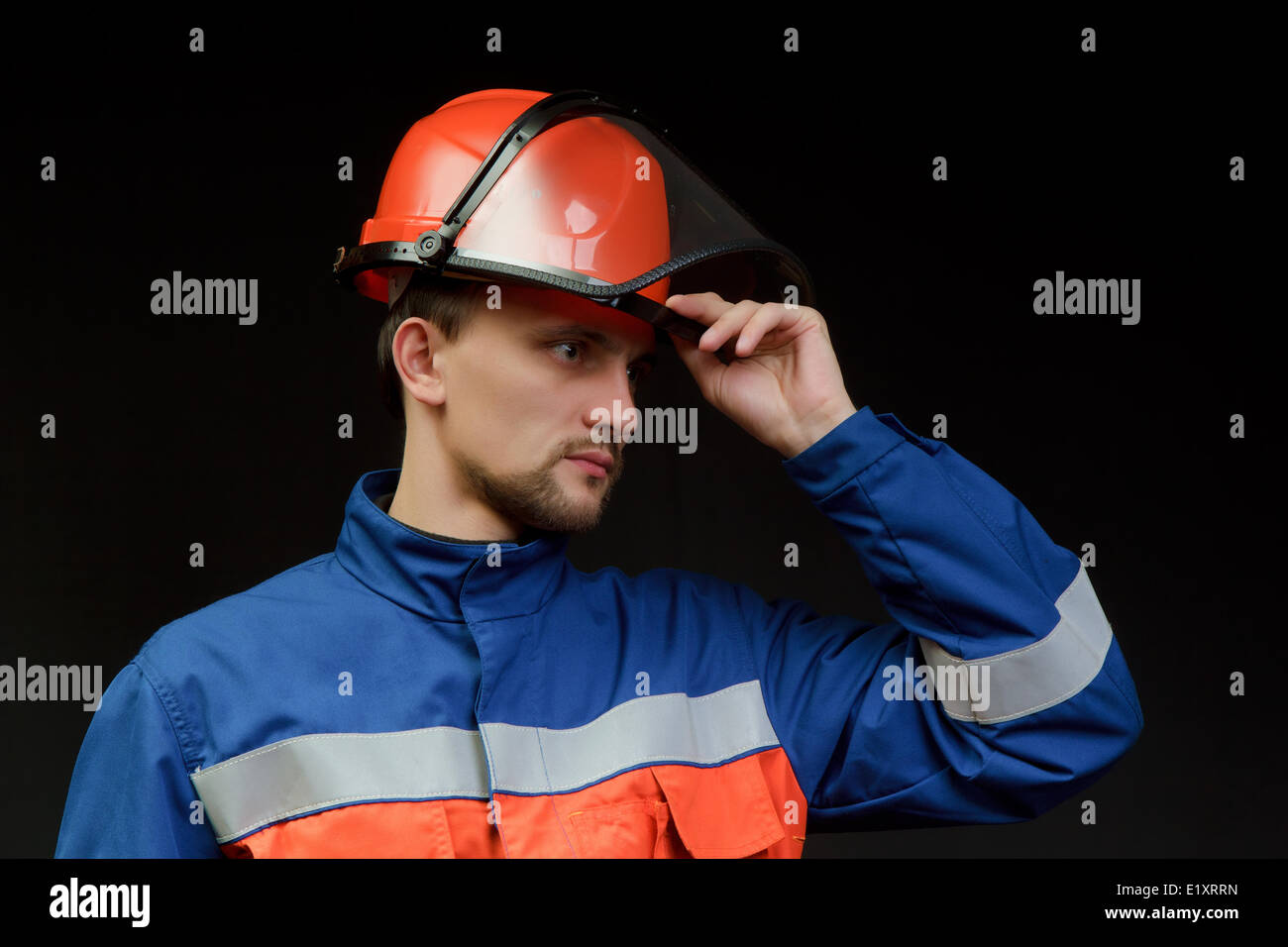 The worker in overalls and a helmet Stock Photo - Alamy