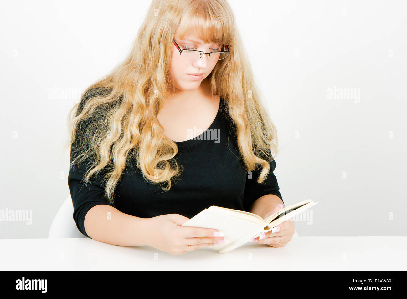blonde girl with glasses reading Stock Photo - Alamy