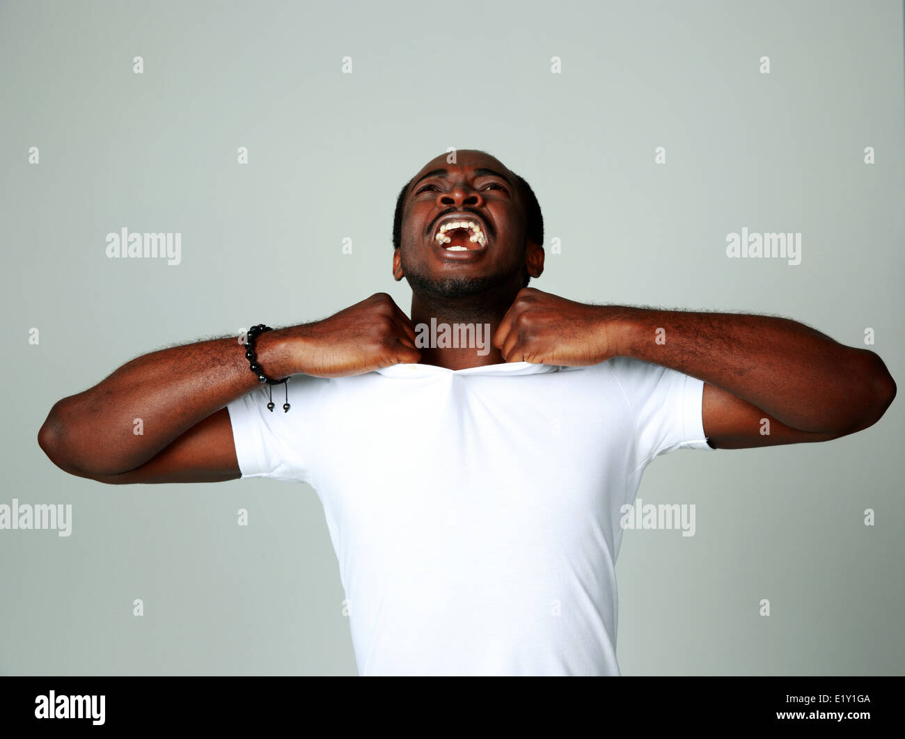 Angry african man screaming on gray background Stock Photo - Alamy