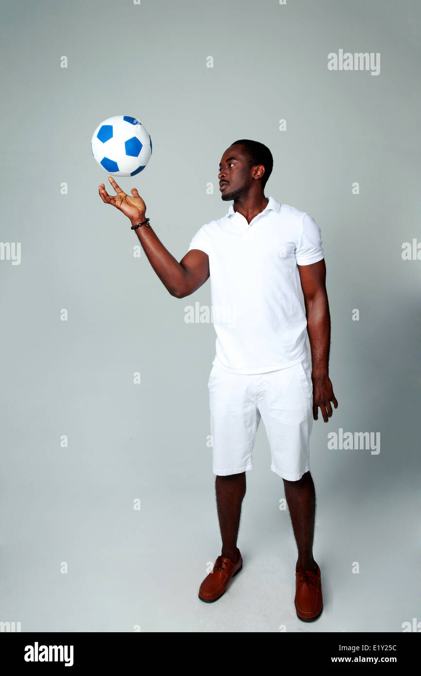 African man spinning a ball on his finger on gray background Stock ...