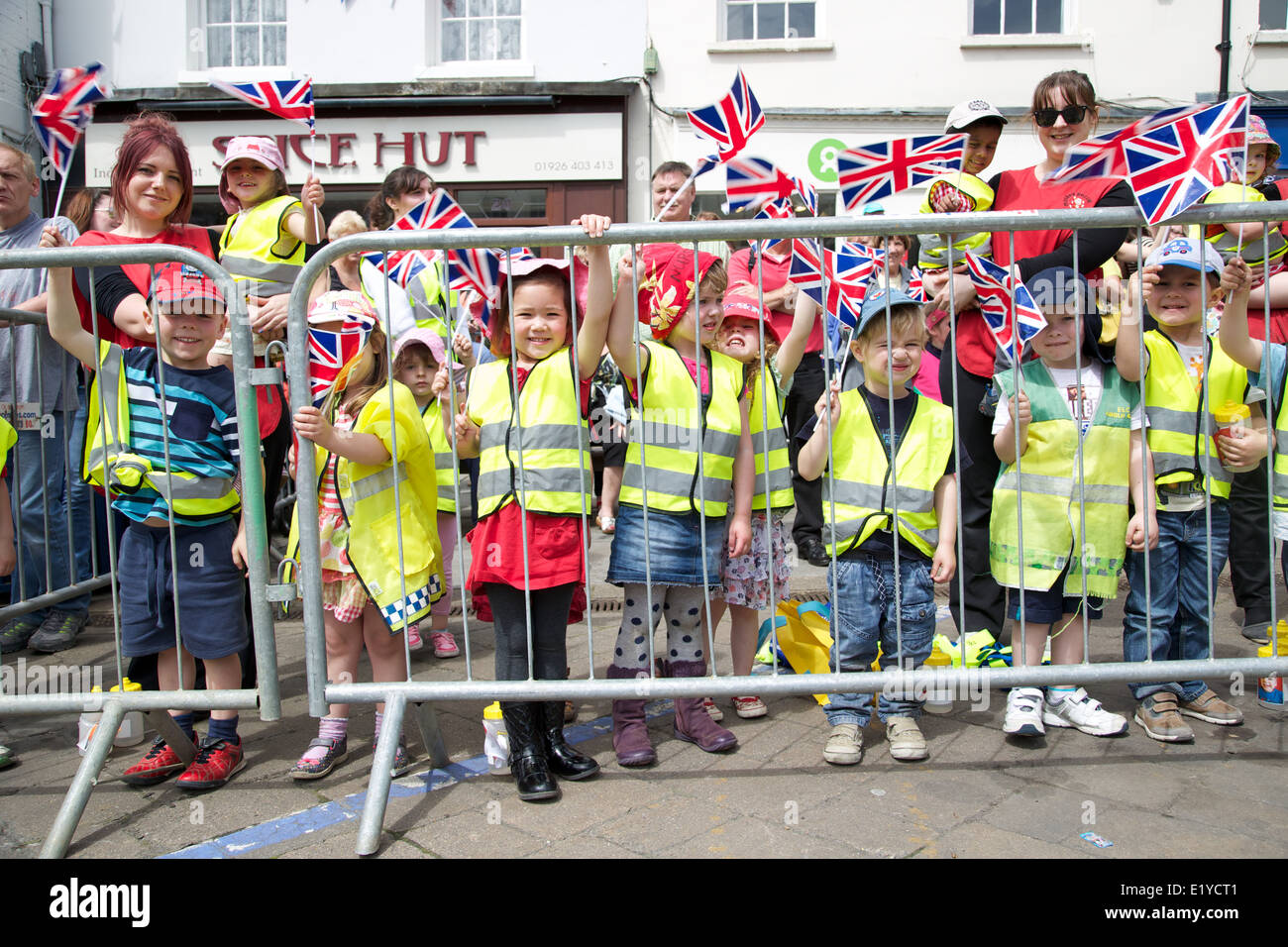 group of small children wave their union jack flags at a parade in ...