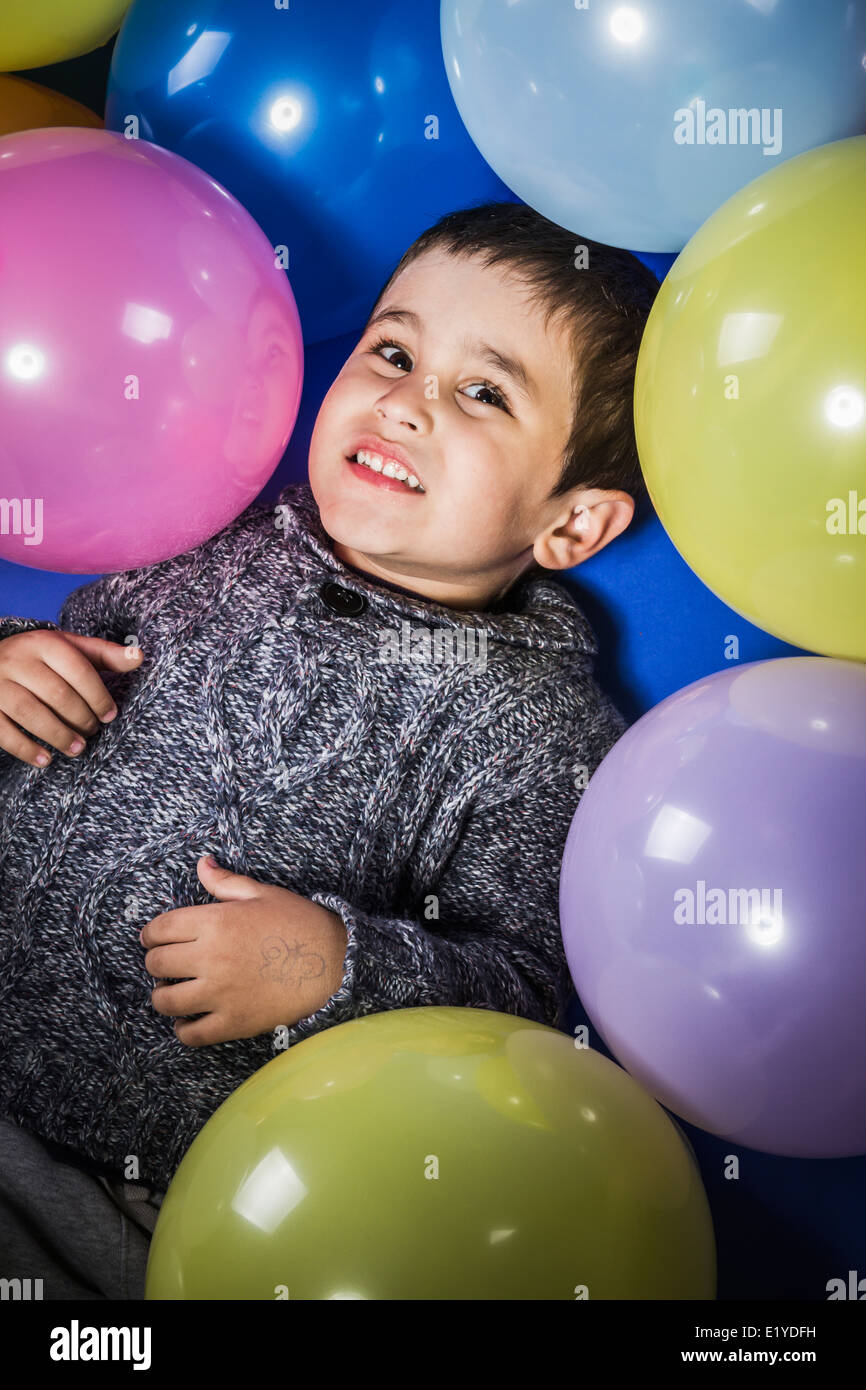 Cute boy playing with balloons of many colors Stock Photo - Alamy