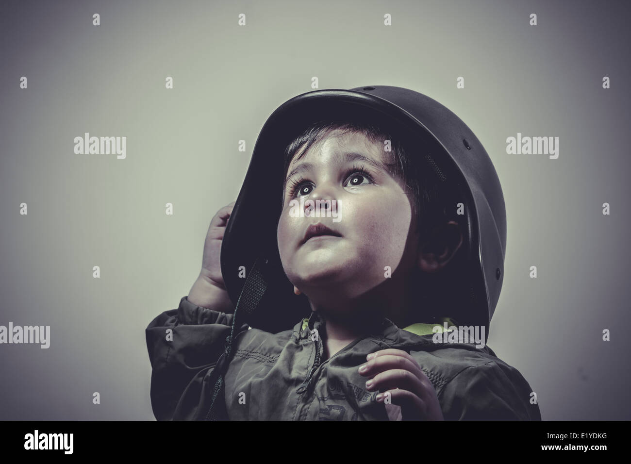 fighter, fun and funny child dressed in military cap, playing war games ...