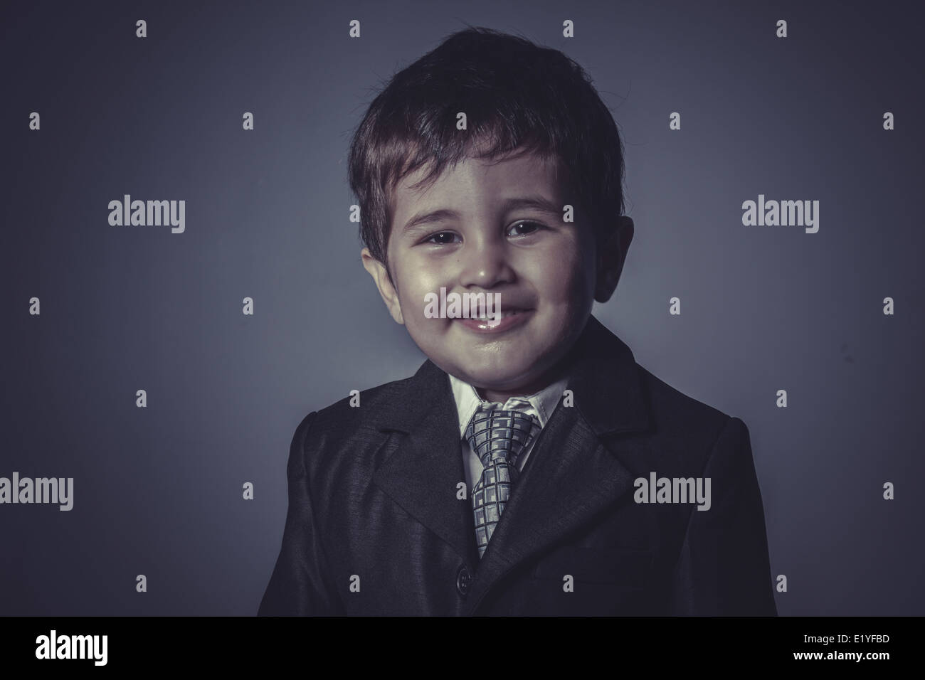 happy little business boy over grey background Stock Photo - Alamy