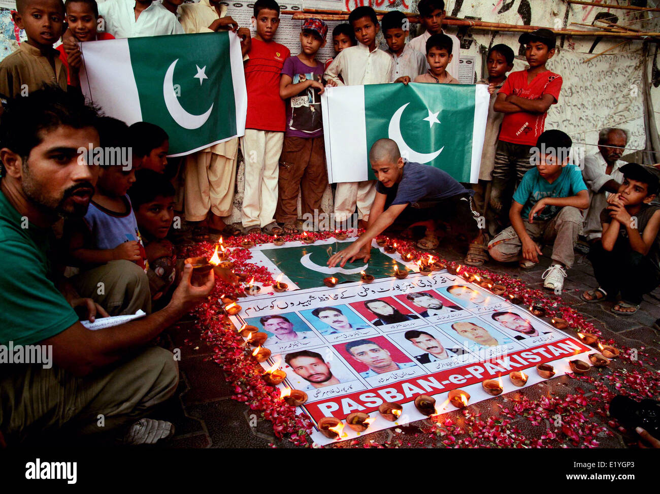 Karachi. 11th June, 2014. Pakistani people gathered around pictures of ...