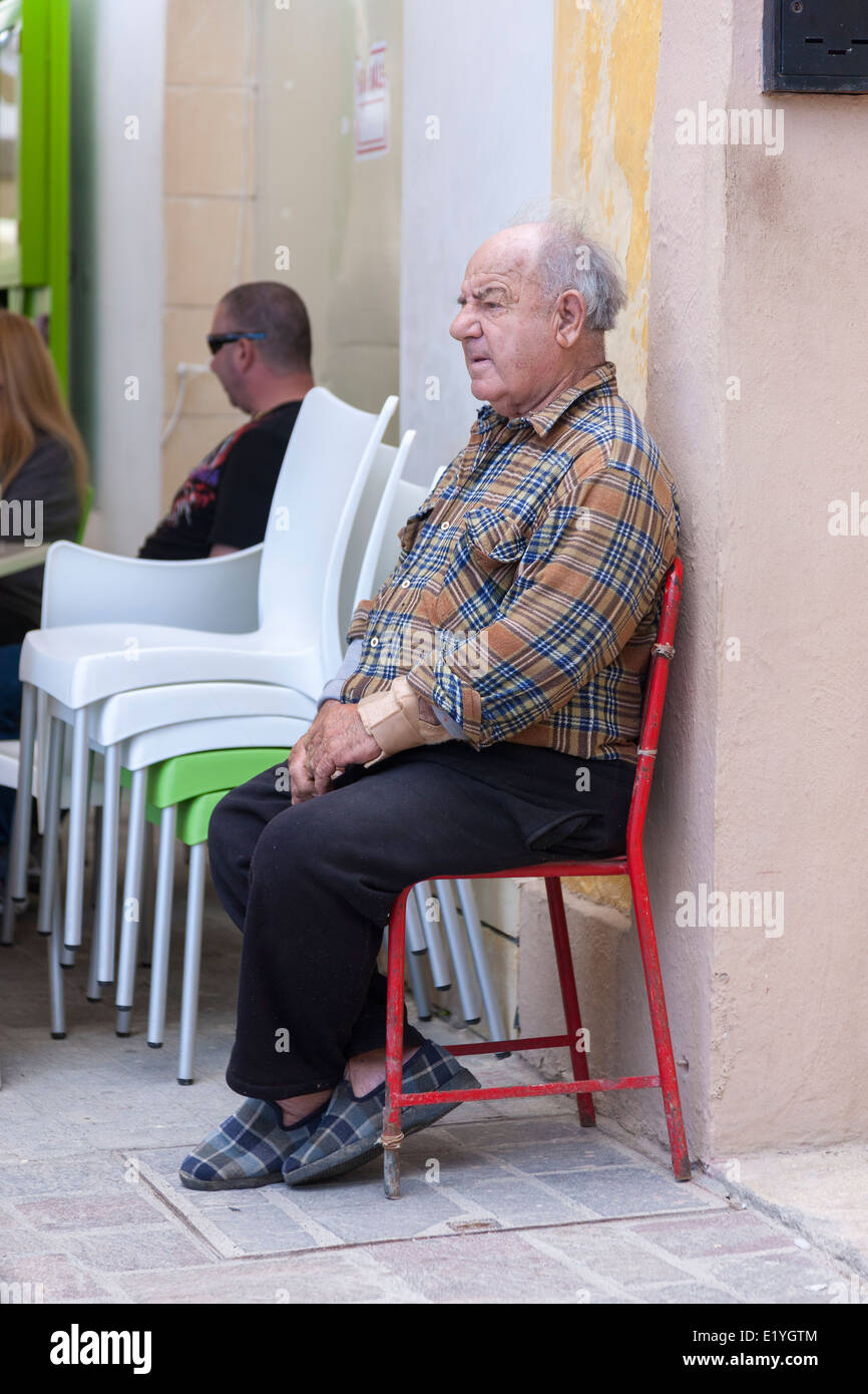 Older man sat near the waterfront in Marsaxlokk Malta Stock Photo - Alamy