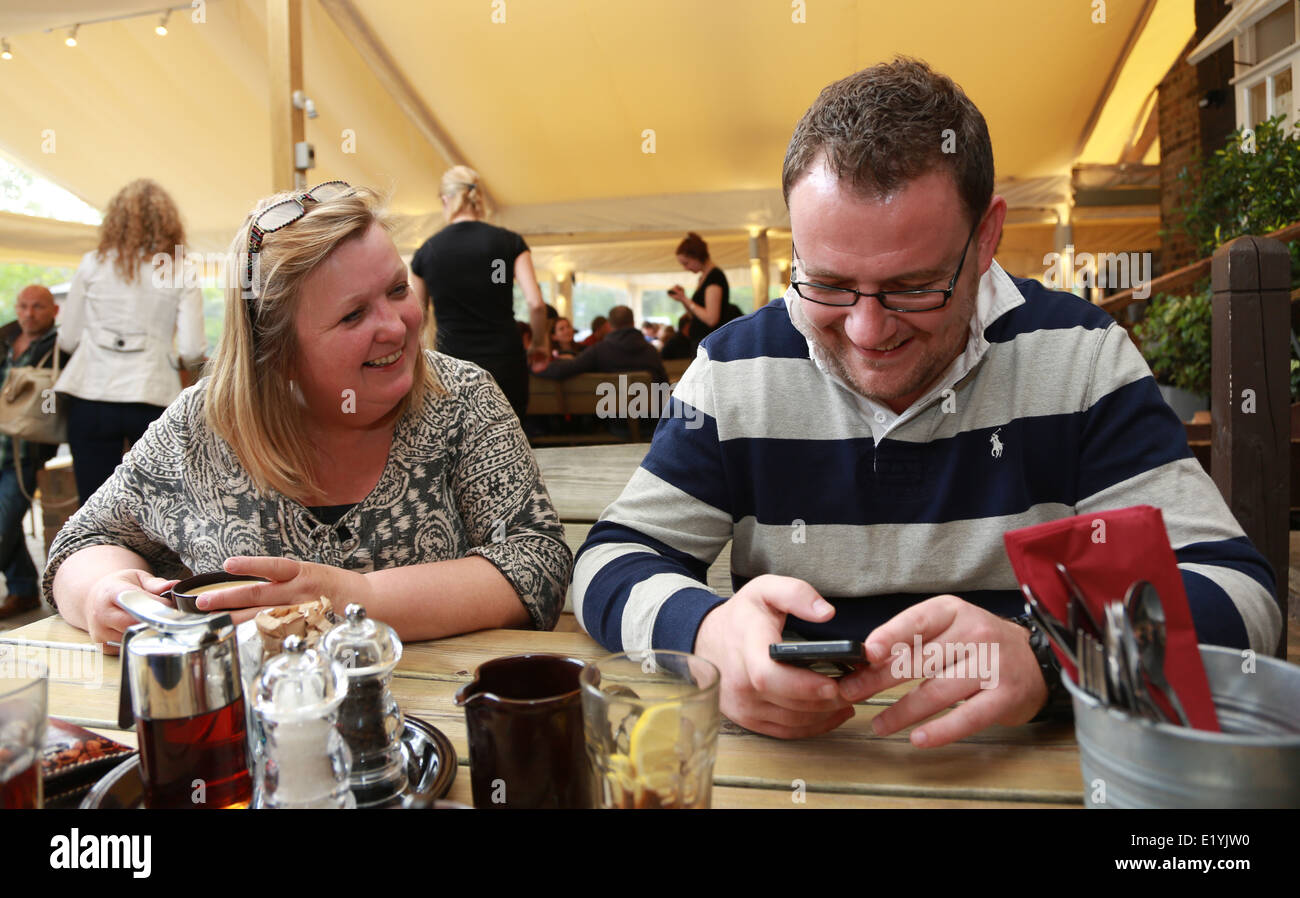 Man texting whilst eating out Stock Photo - Alamy