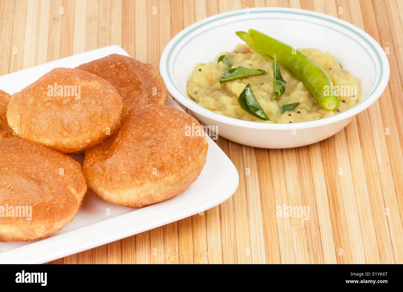 Delicious deep fried poori (puri) served with spicy potato onion curry ...
