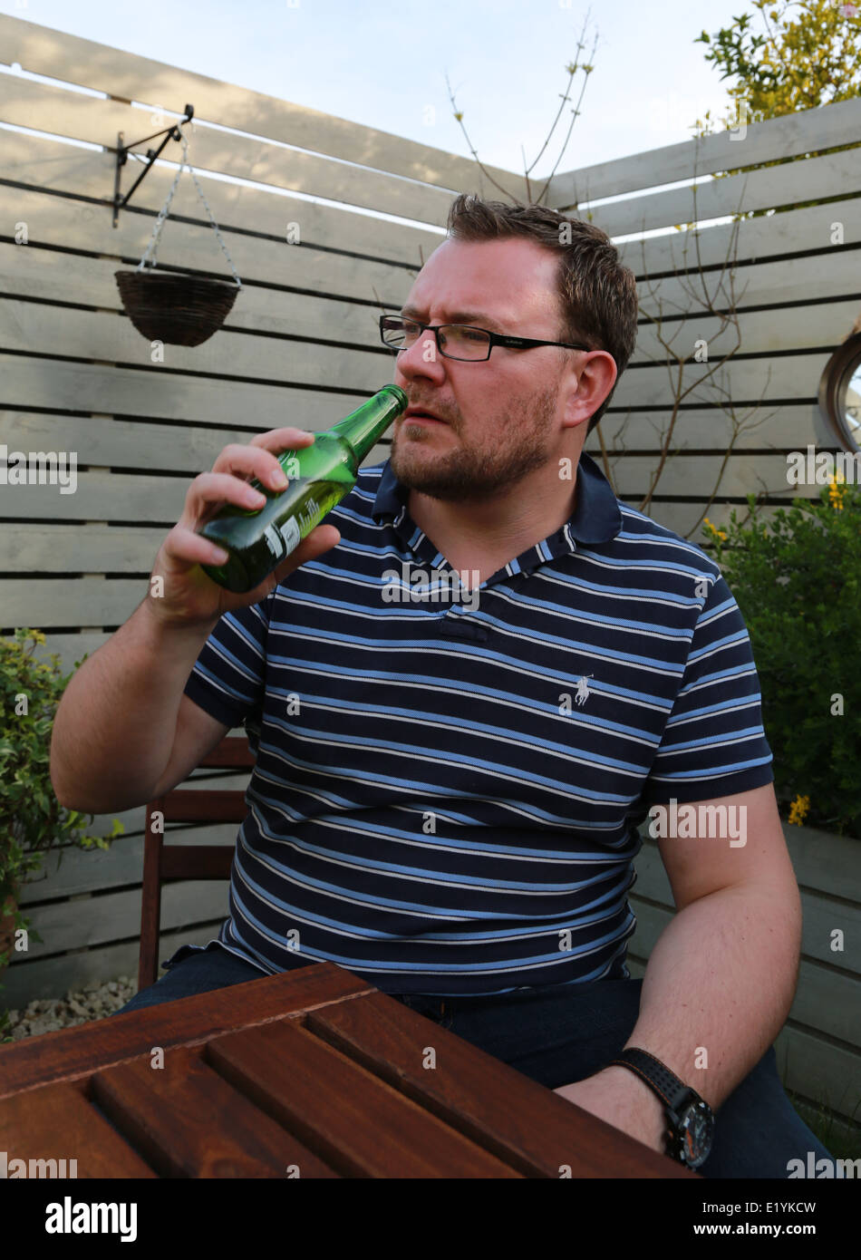 Drunk man drinking beer Stock Photo - Alamy