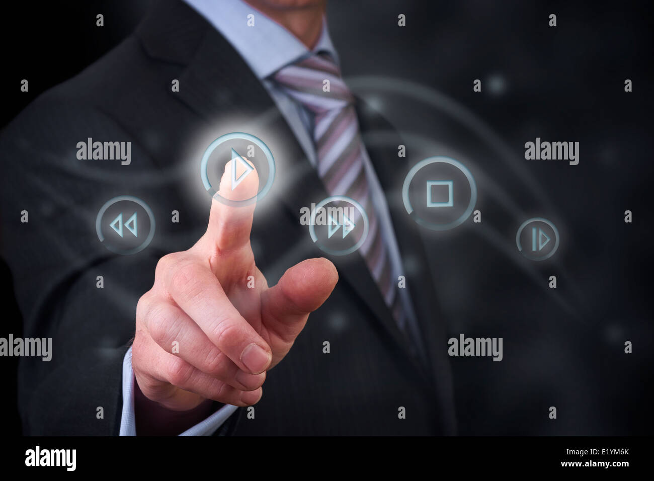 A man pressing a button on a digital screen to control digital media ...