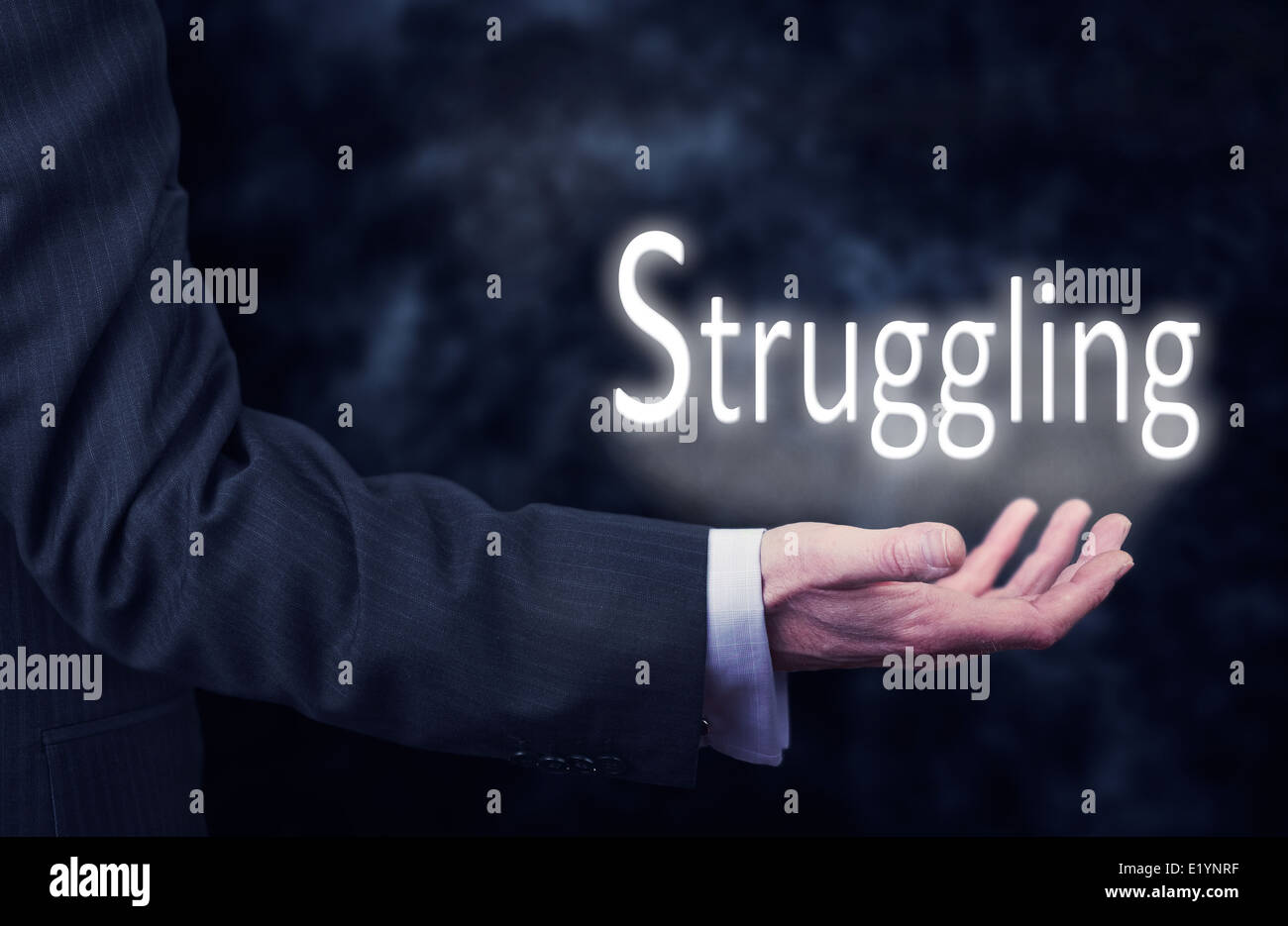A businessmans hand holding the word, struggling Stock Photo - Alamy
