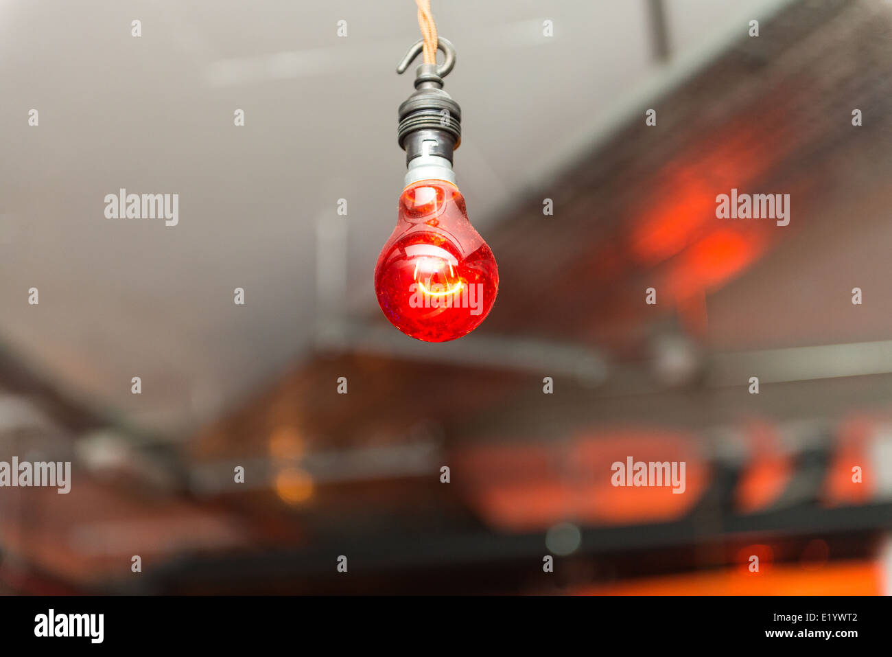A hanging red light bulb Stock Photo - Alamy