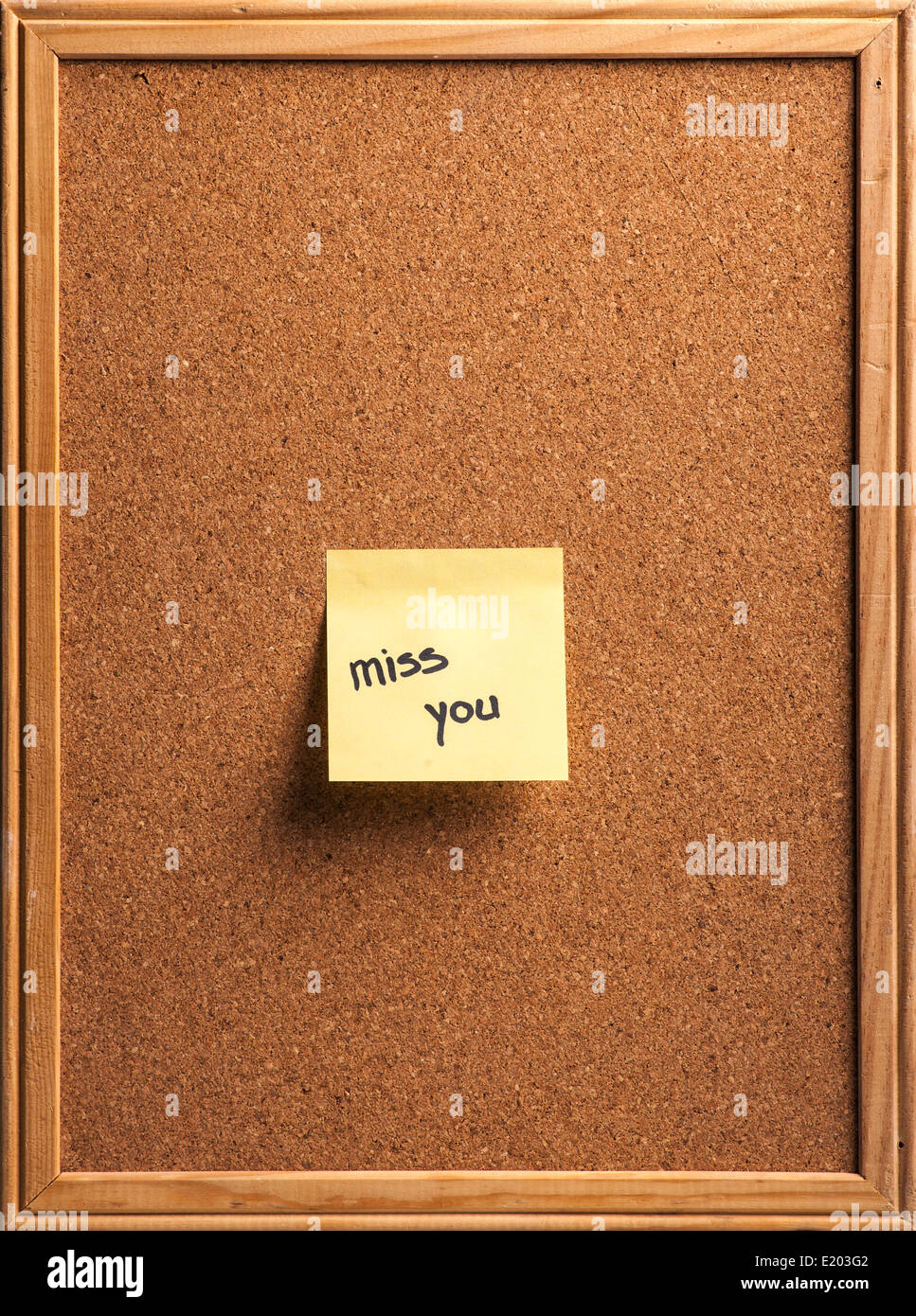 Color shot of a cork board with a sticky note reading "miss you Stock ...