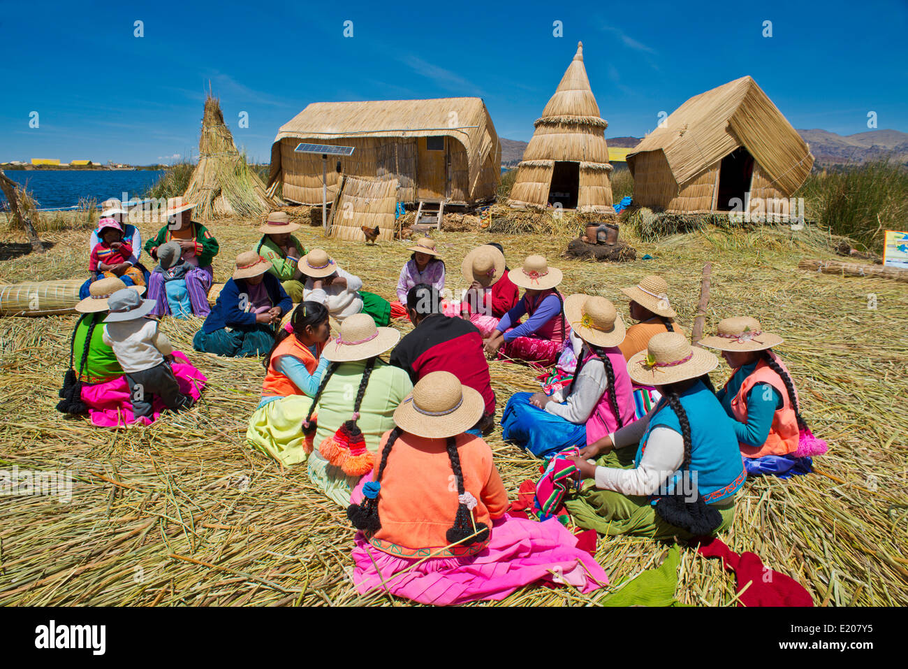 Women of the Uro Indians sit in front of typical reed huts, floating ...
