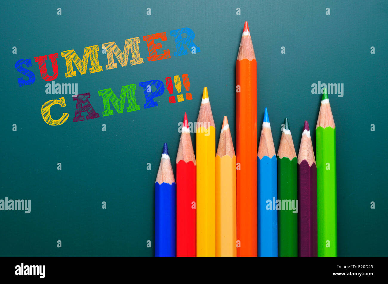 text summer camp written on a chalkboard and some colored pencils of ...