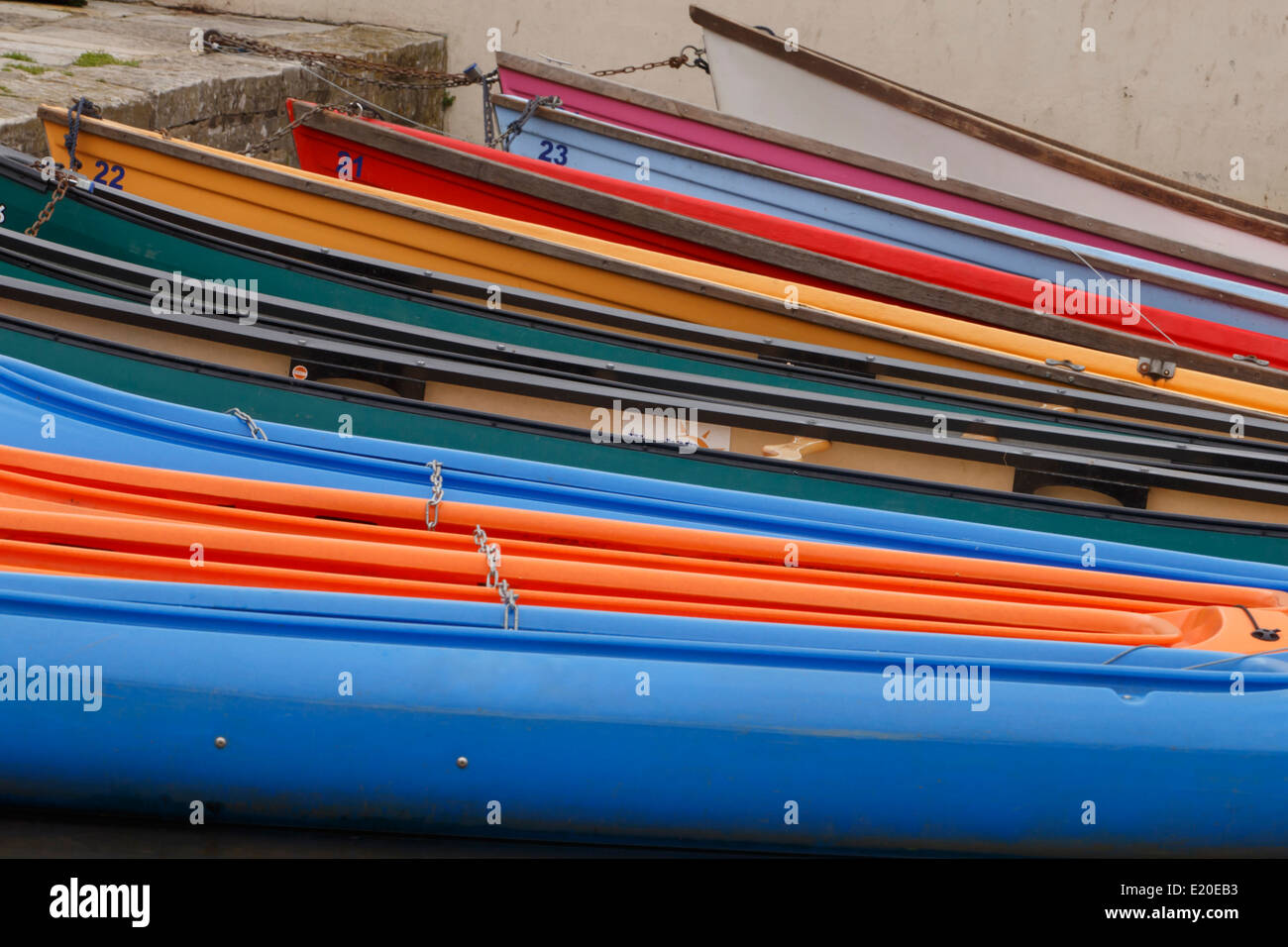 Various colored boats lined up on shore Stock Photo - Alamy