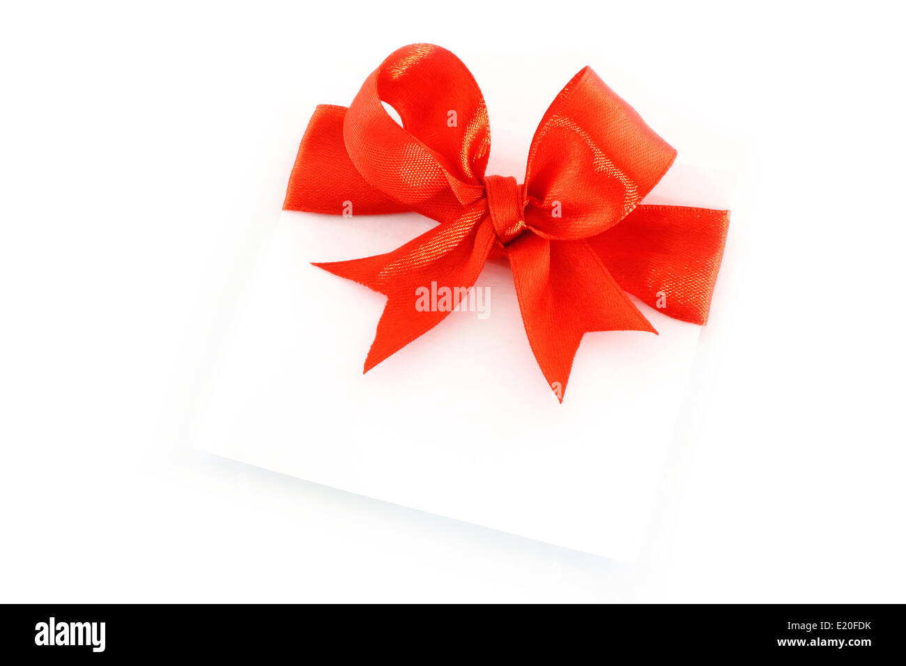 Sheet with red holiday bow on white background Stock Photo - Alamy