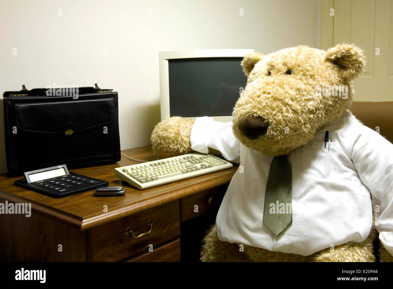 Oversized bear dressed as an office worker sitting at a desk with a ...
