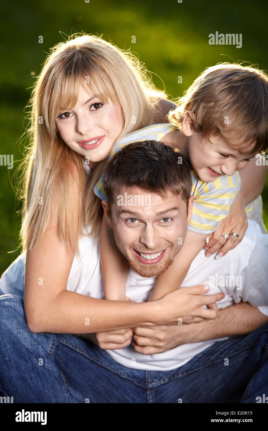 Happy couple and the child on a lawn Stock Photo - Alamy