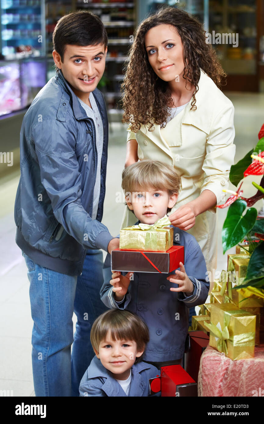 Happy family in shop with boxes of gifts Stock Photo - Alamy