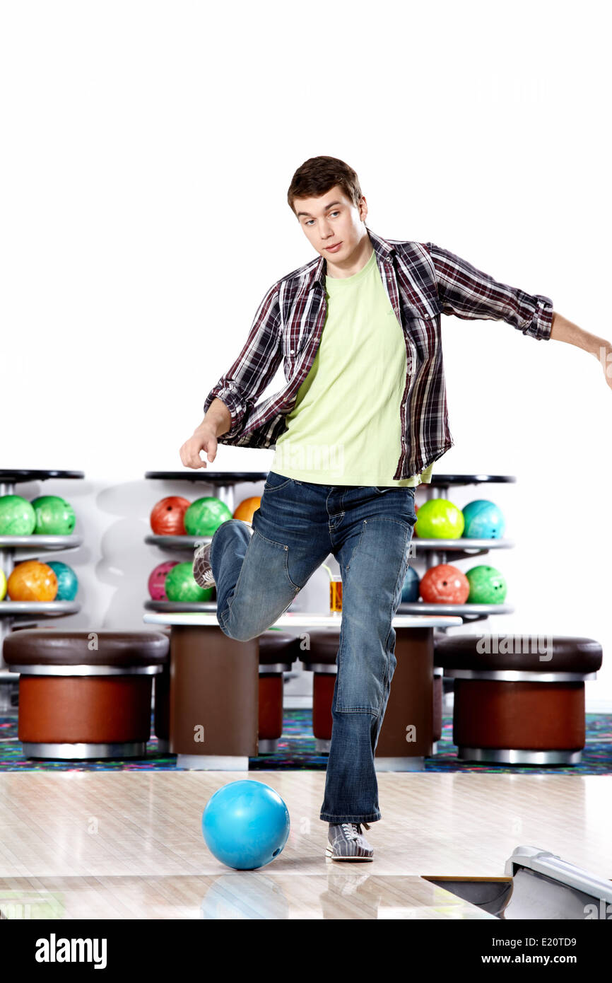 The young man kicks a sphere for bowling Stock Photo - Alamy