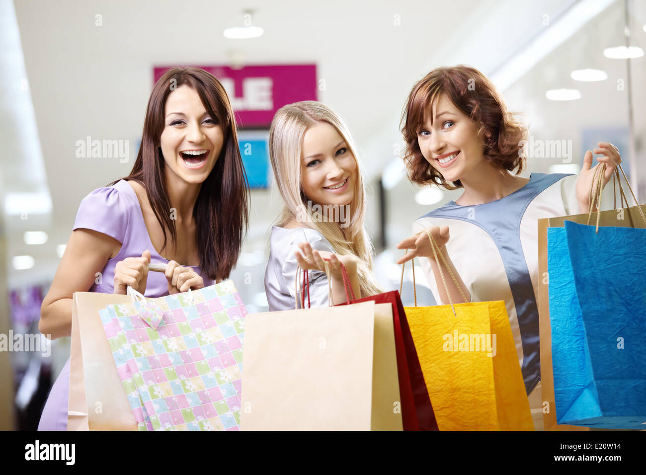 Happy smiling girls in shop with purchases Stock Photo - Alamy