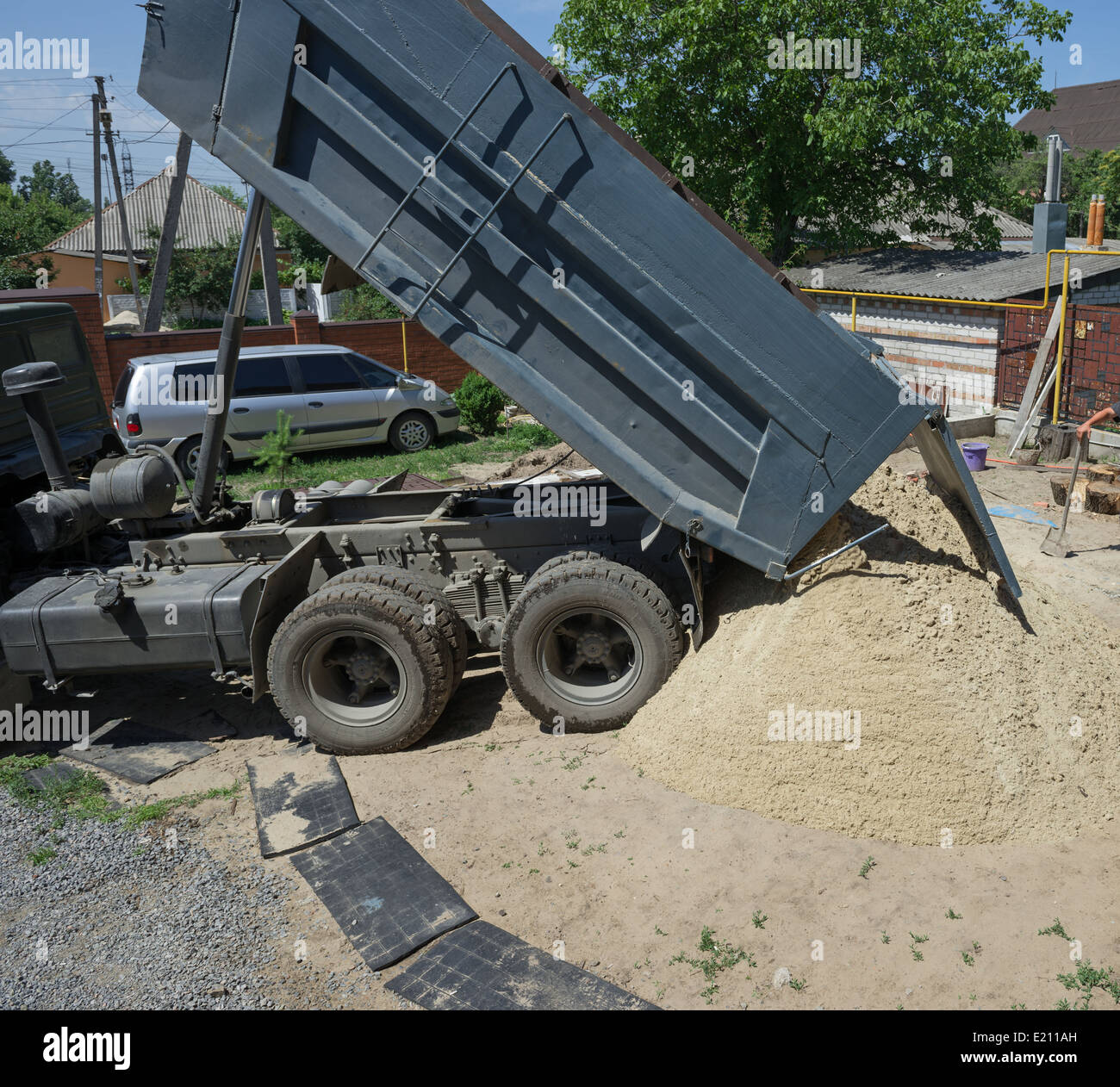 Tip truck is dumping sand in the backyard Stock Photo - Alamy