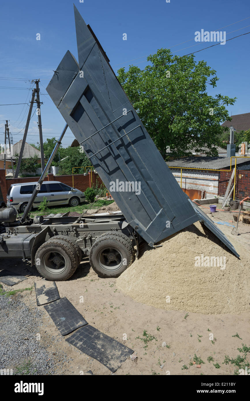 Tip truck is dumping sand in the backyard Stock Photo - Alamy