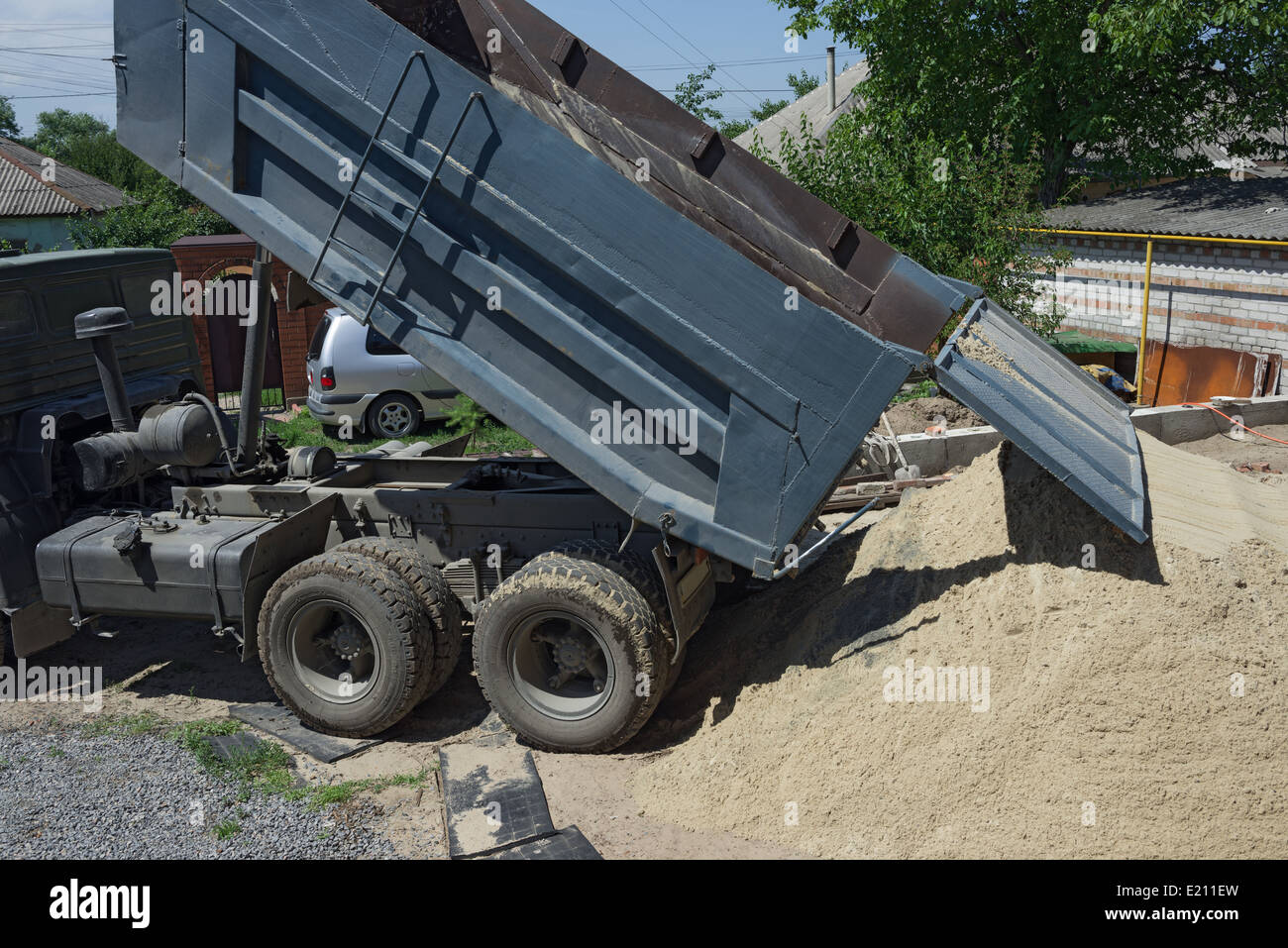 Tip truck is dumping sand in the backyard Stock Photo - Alamy
