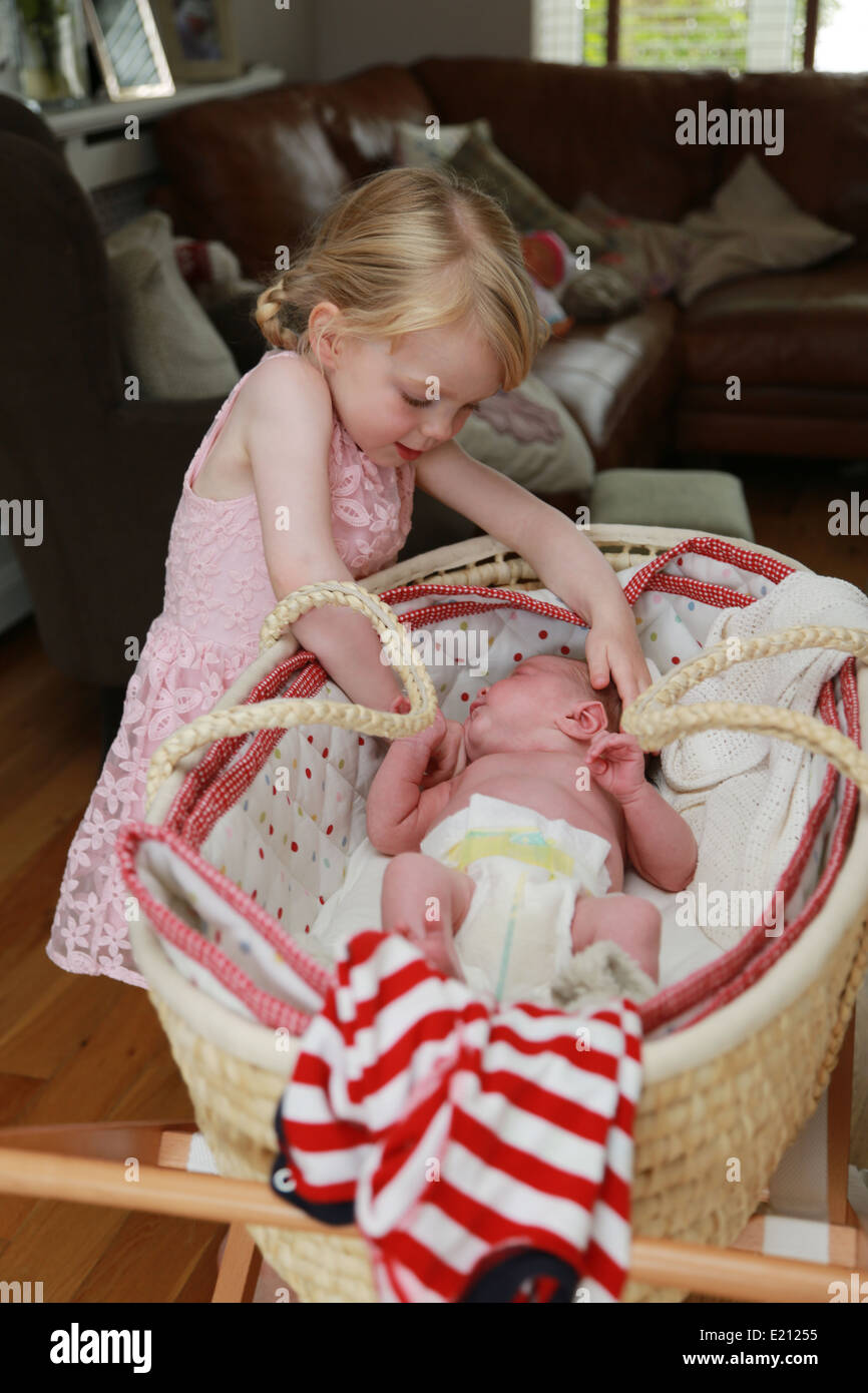 Young child helping with newborn baby brother Stock Photo - Alamy