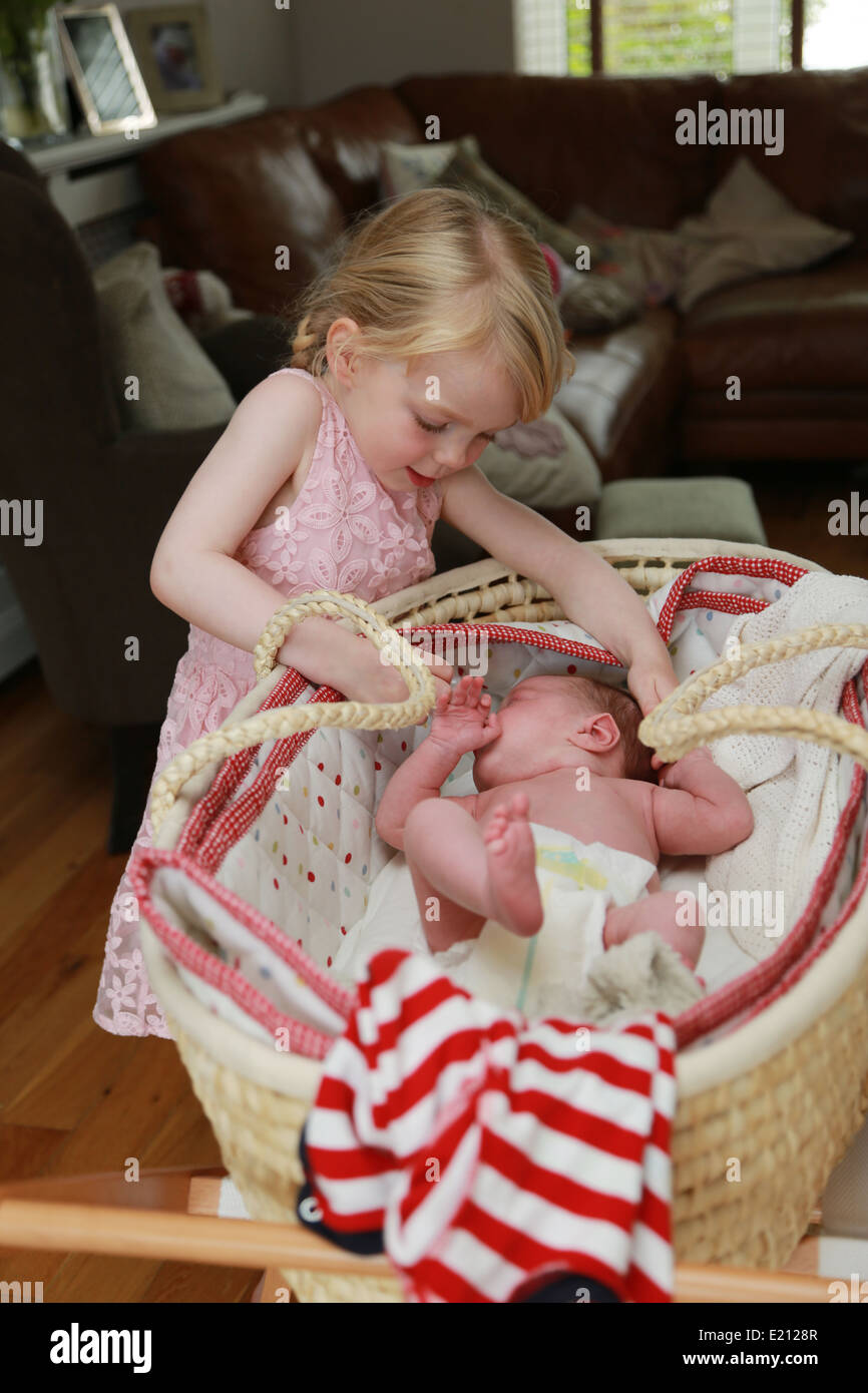 Young child helping with newborn baby brother Stock Photo - Alamy