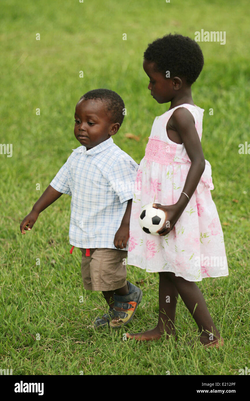 A young girl and even younger boy, both orphans, play together Stock ...