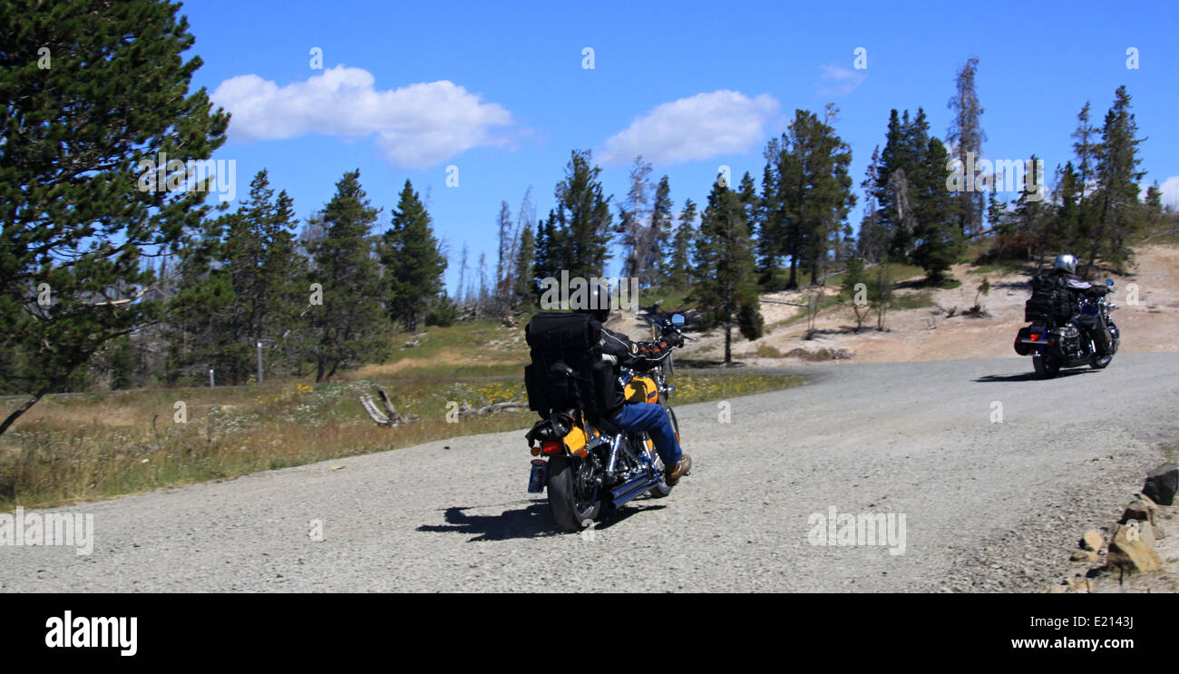 Two moto bikers on mountainous highway in Yellowstone national park ...