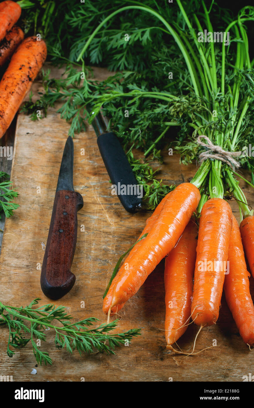 Bunch of fresh carrot with vintage knife on old cutting board Stock ...