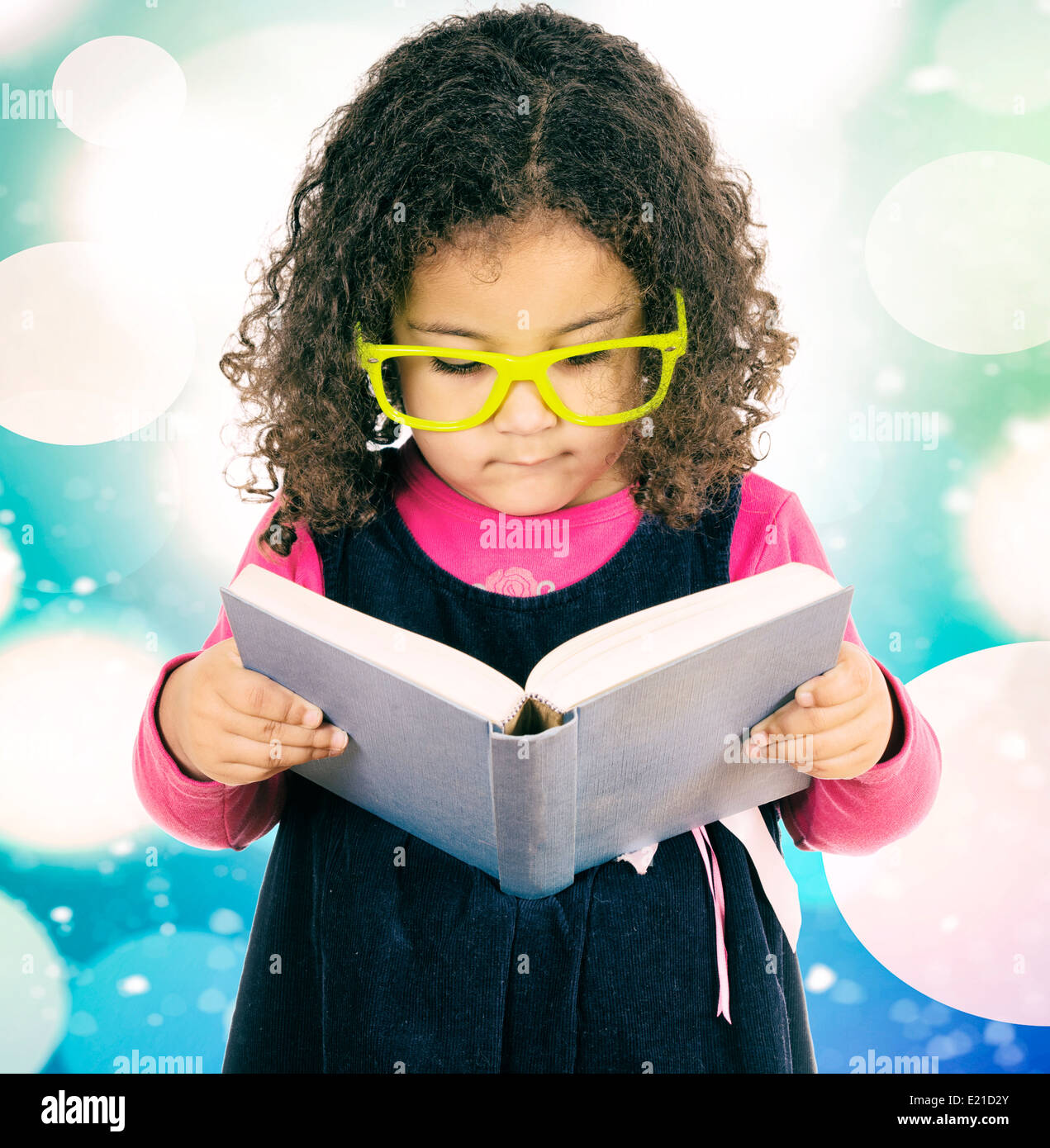 Little child holding the book and reading Stock Photo - Alamy