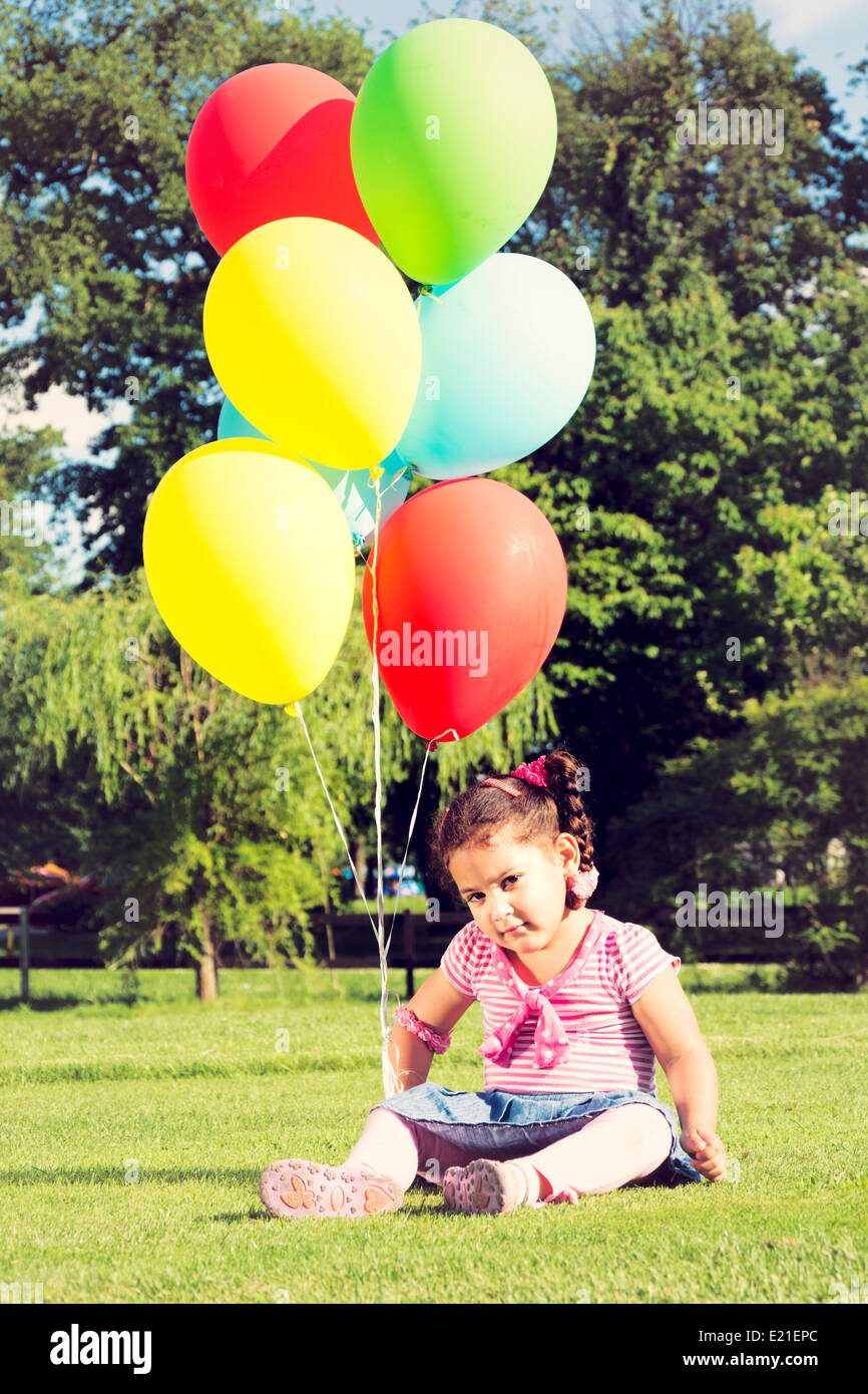 Little angry child in the park with colorful balloons Stock Photo - Alamy