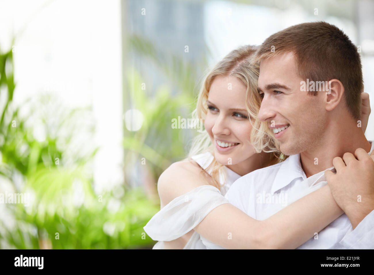 Happy young couple looking to one side Stock Photo - Alamy