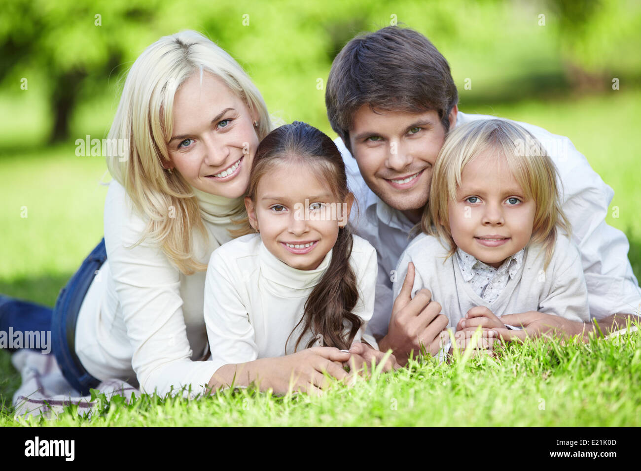 Young parents with children on the grass Stock Photo - Alamy