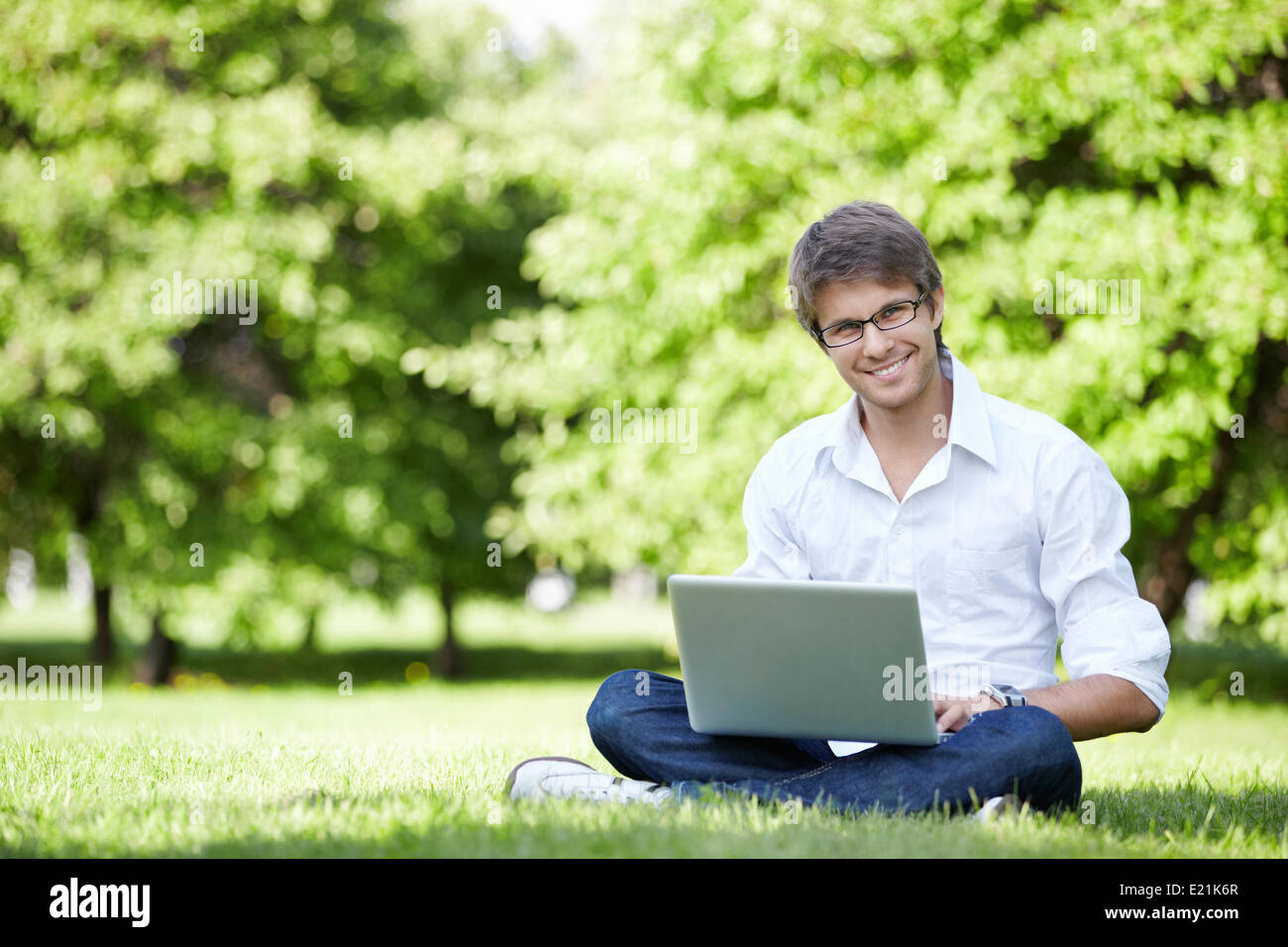 A young man with laptop outdoor Stock Photo - Alamy