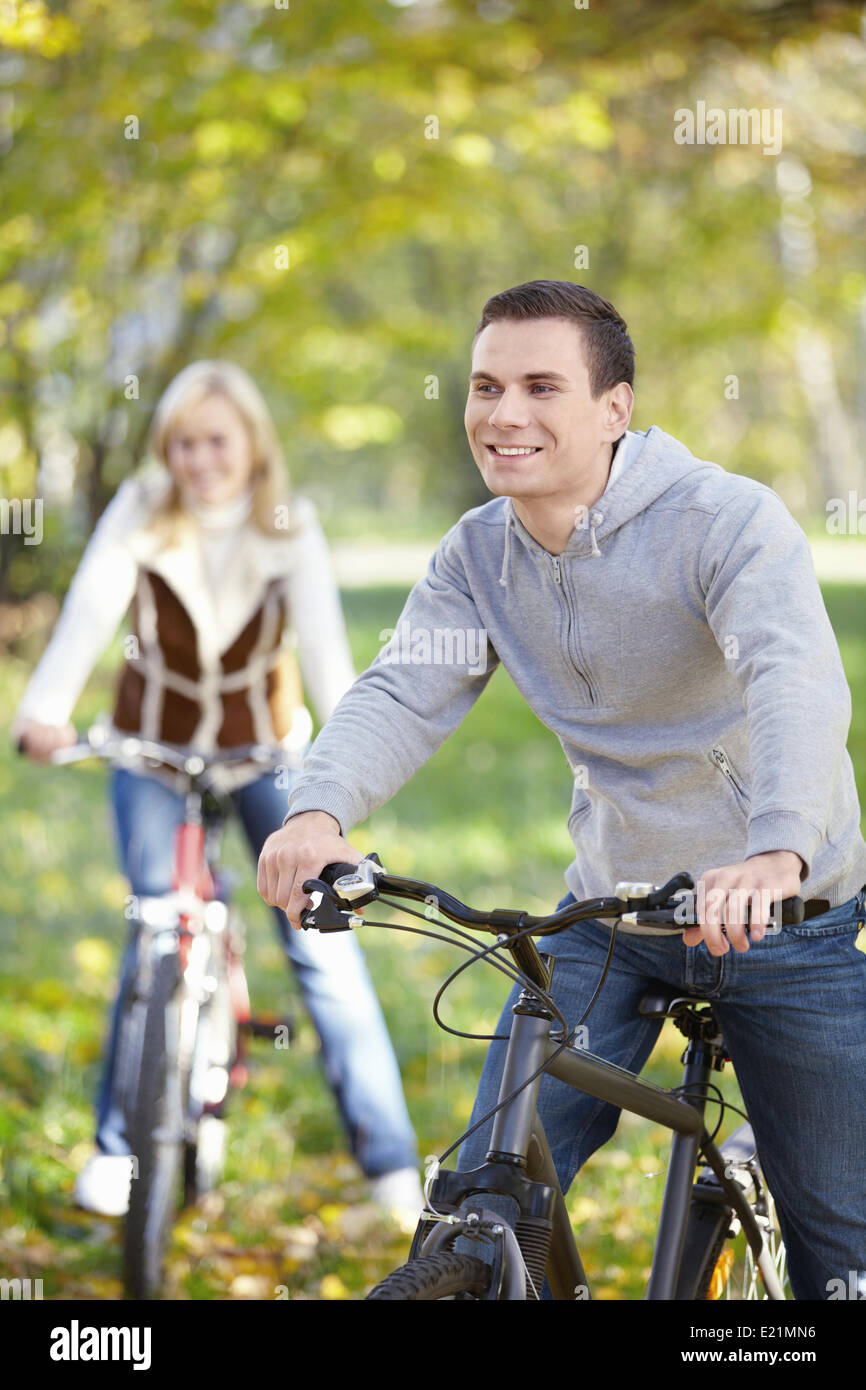Couple cycling in autumn park Stock Photo - Alamy