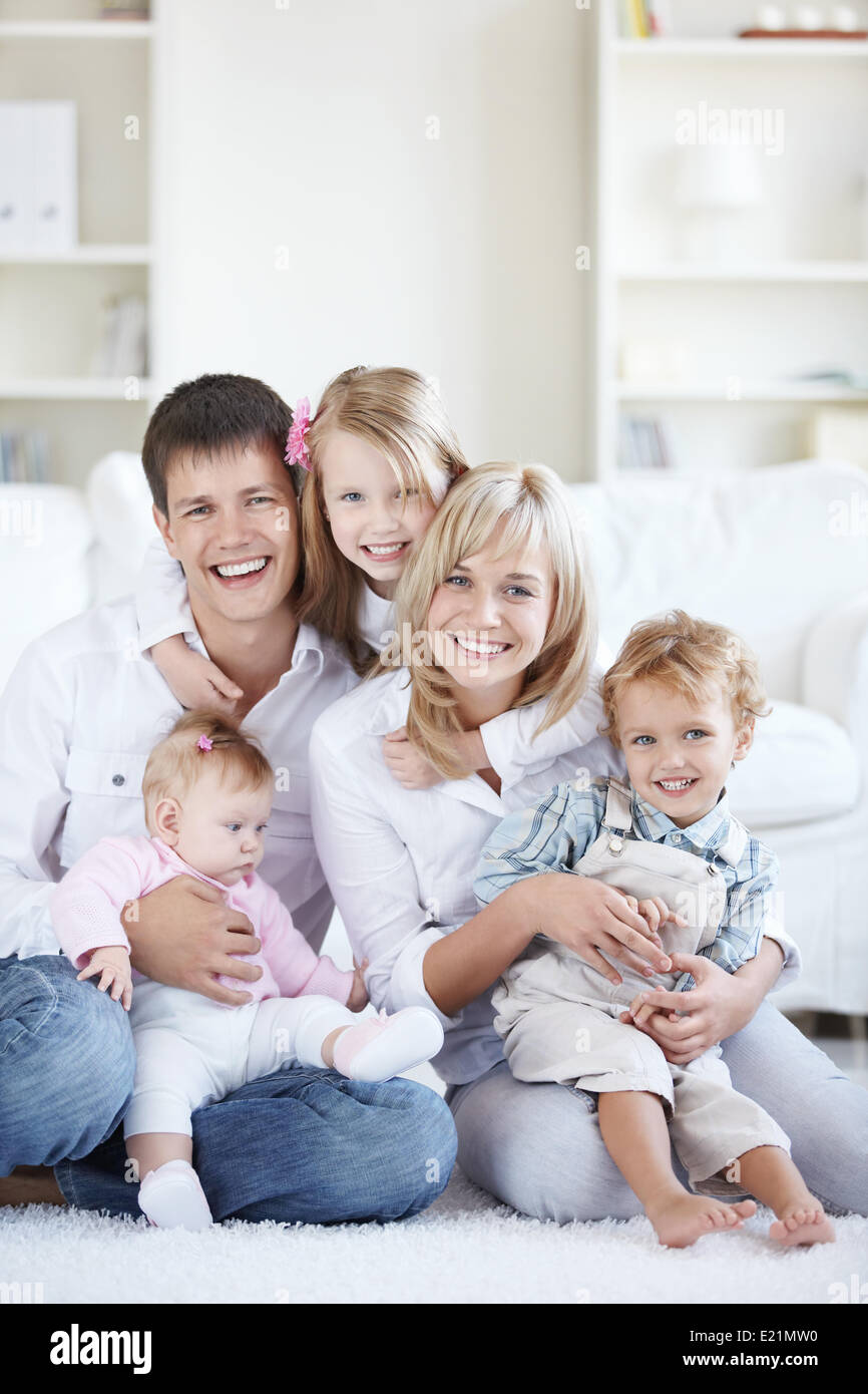 Happy parents with three children at home Stock Photo - Alamy