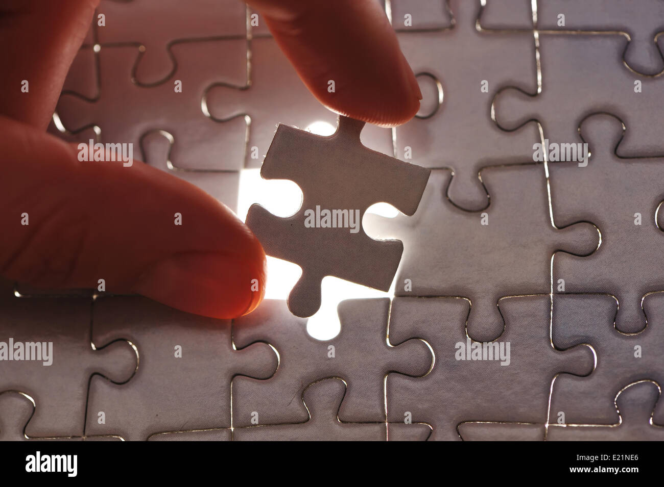 Hand placing missing puzzle piece Stock Photo - Alamy