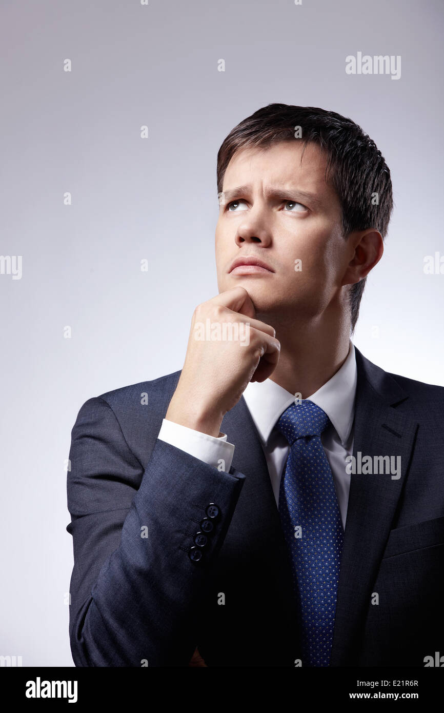 A young man in a suit thought Stock Photo - Alamy