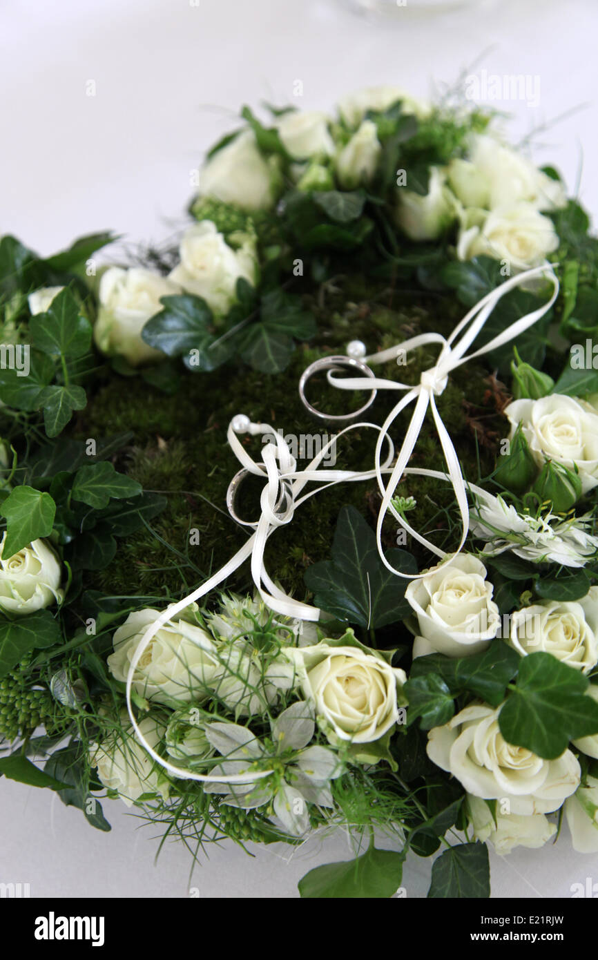 Wedding rings on a heart of white roses Stock Photo - Alamy