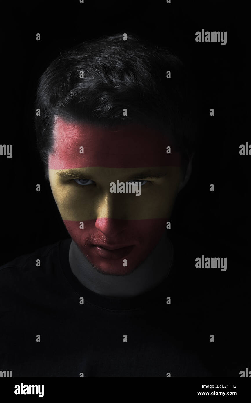 serious man face with painted flag colors of Spain, black background ...
