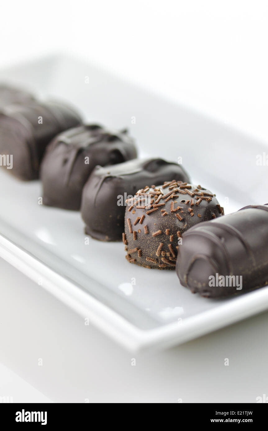 chocolate candies assortment in a white plate Stock Photo - Alamy