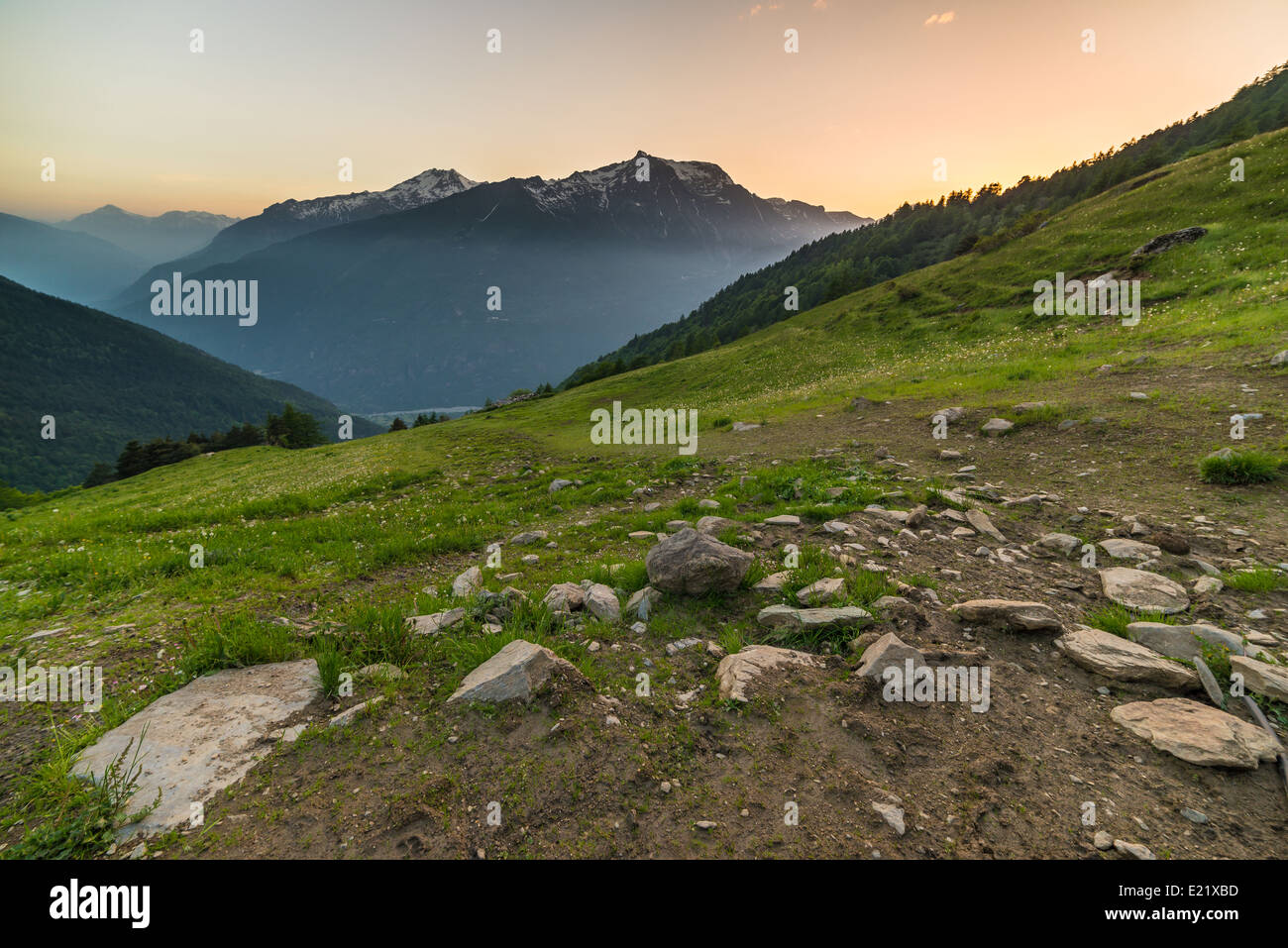 Dawn time in the italian Alps on rocky and grassy landscape overlookign ...