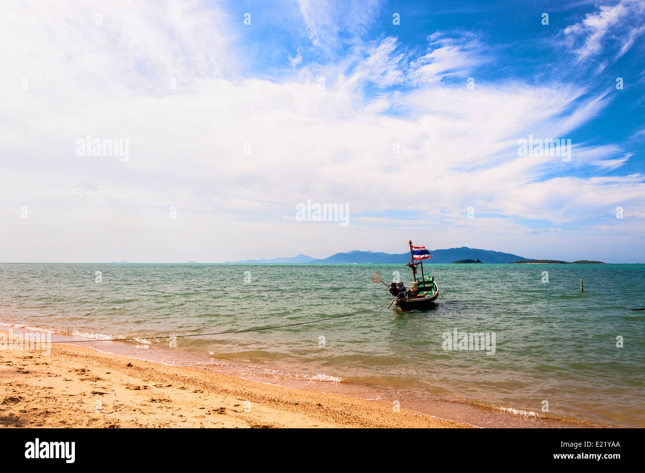 typical fisherman boat with national flag, beach and sea in Koh Samui ...