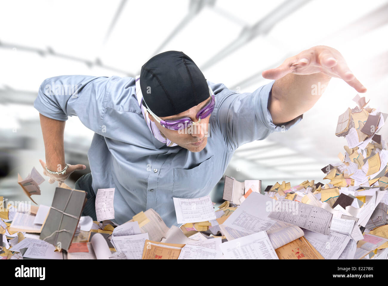 Businessman swimming in a pool of papers Stock Photo - Alamy